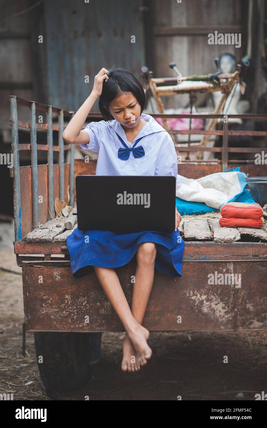 Asian uniform student girl using computer laptop with She has a problem ...