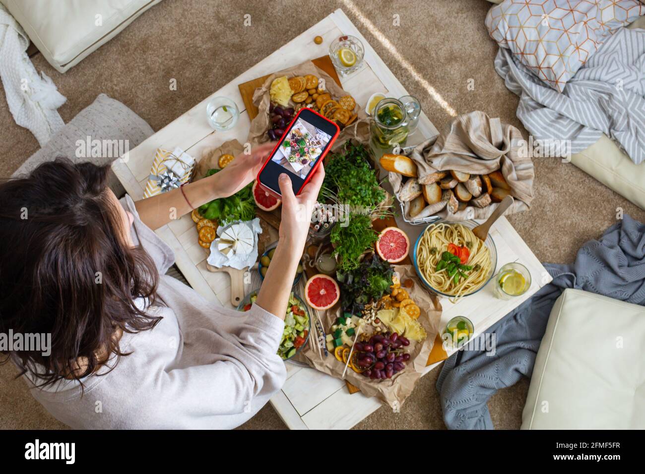 Top view woman photographing dinner table with serving tasty food and ...