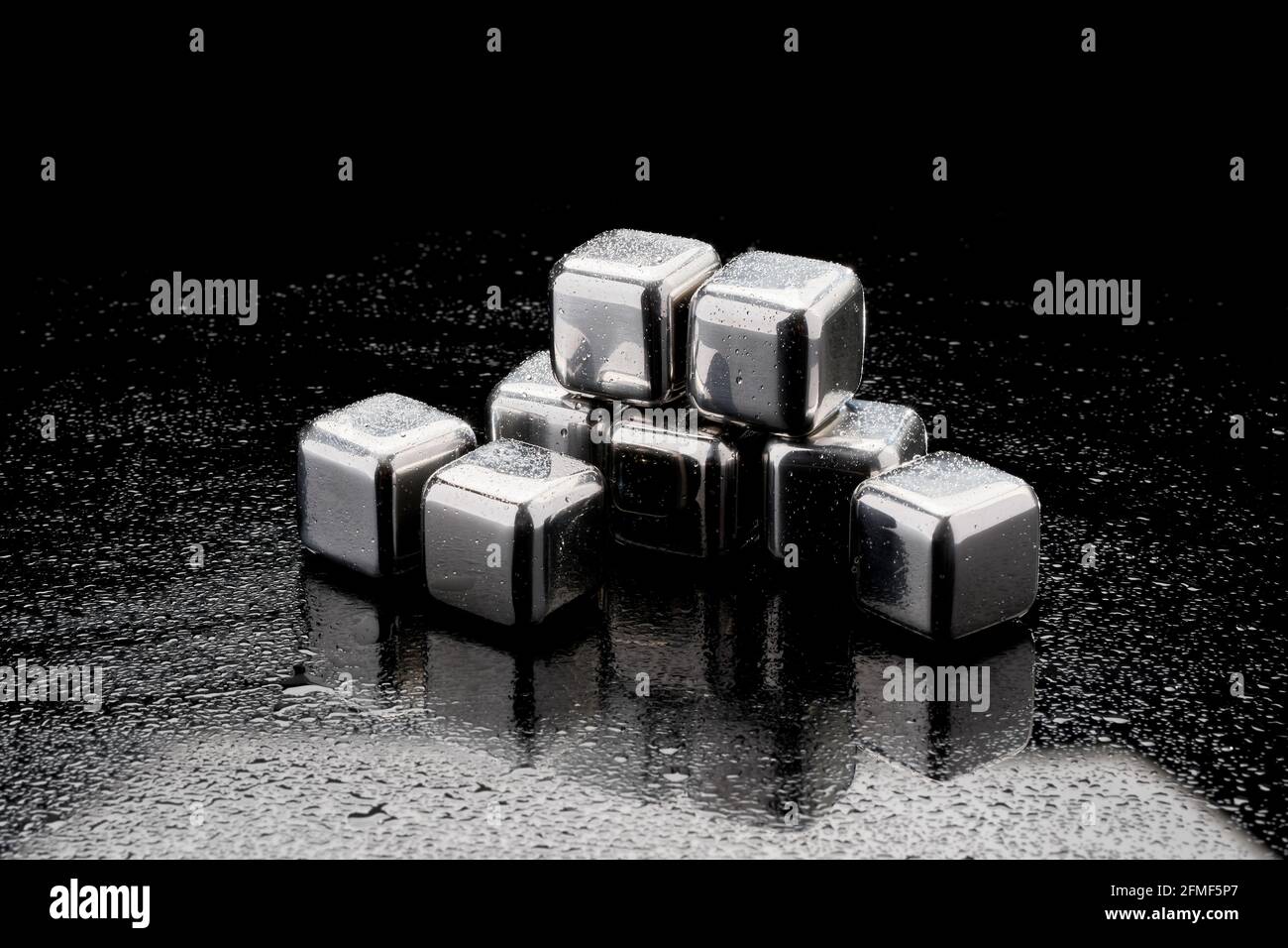 Steel cooling cubes for cocktail drink on glass background Stock Photo ...