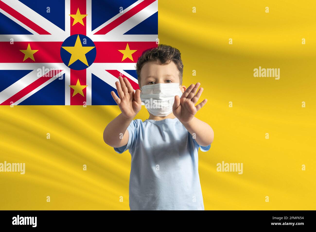 Little white boy in a protective mask on the background of the flag of ...