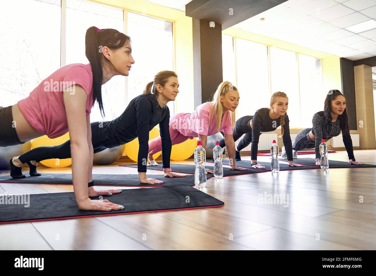 Group of young women doing plank together in gym Stock Photo - Alamy