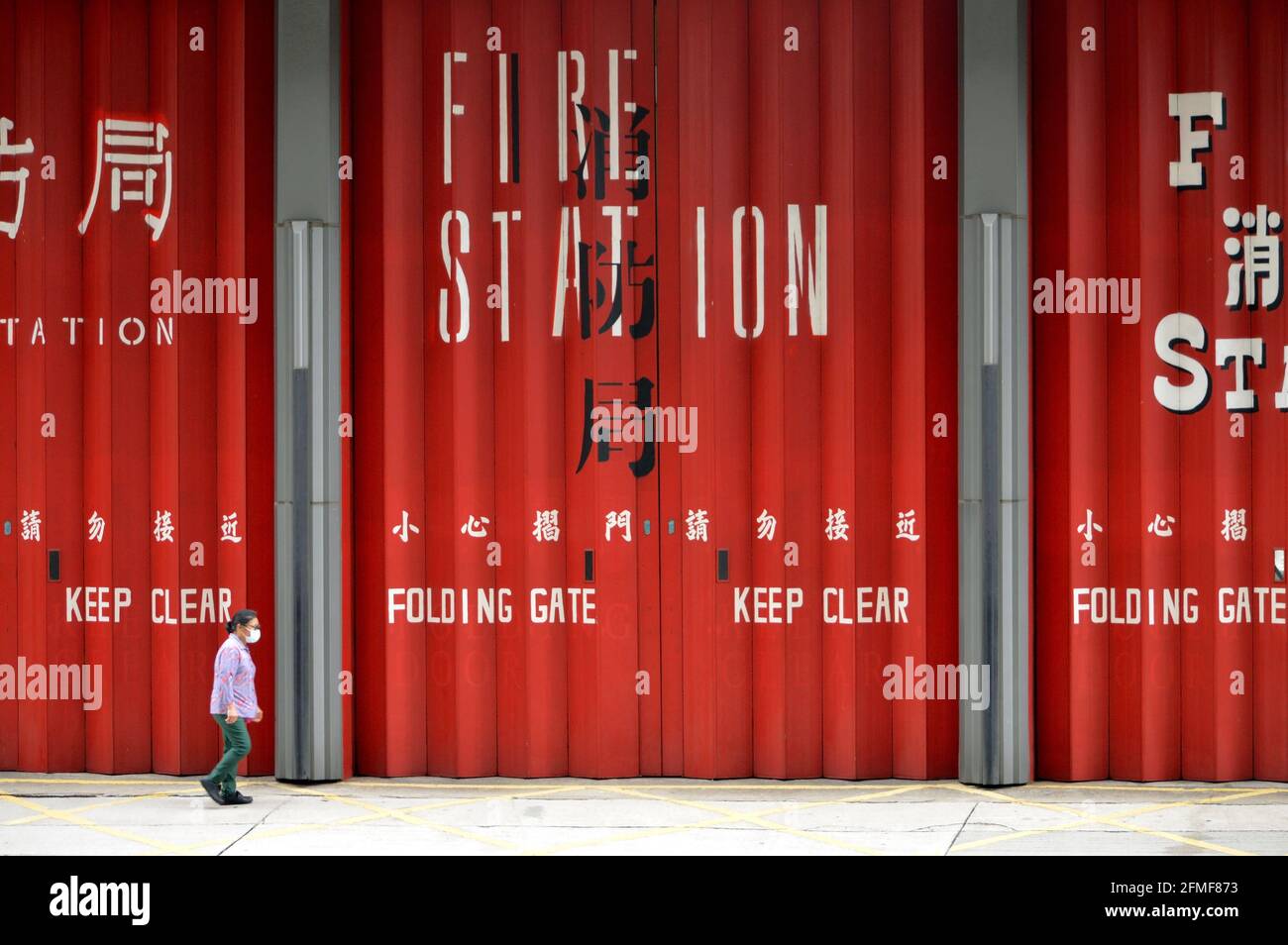 Woman walking past fire station in Hong Kong Stock Photo - Alamy