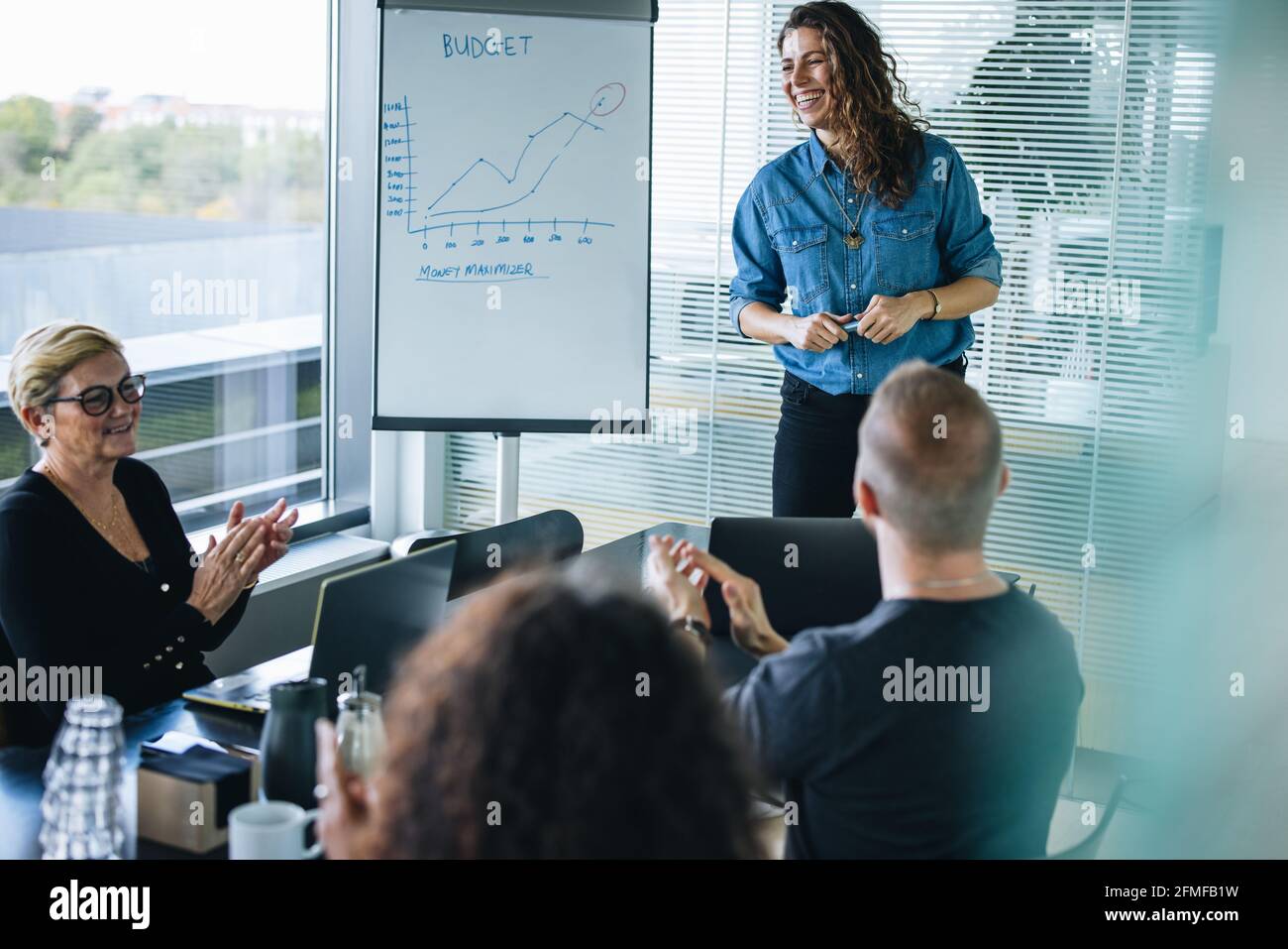 business team clapping for a colleagues after her successful ...