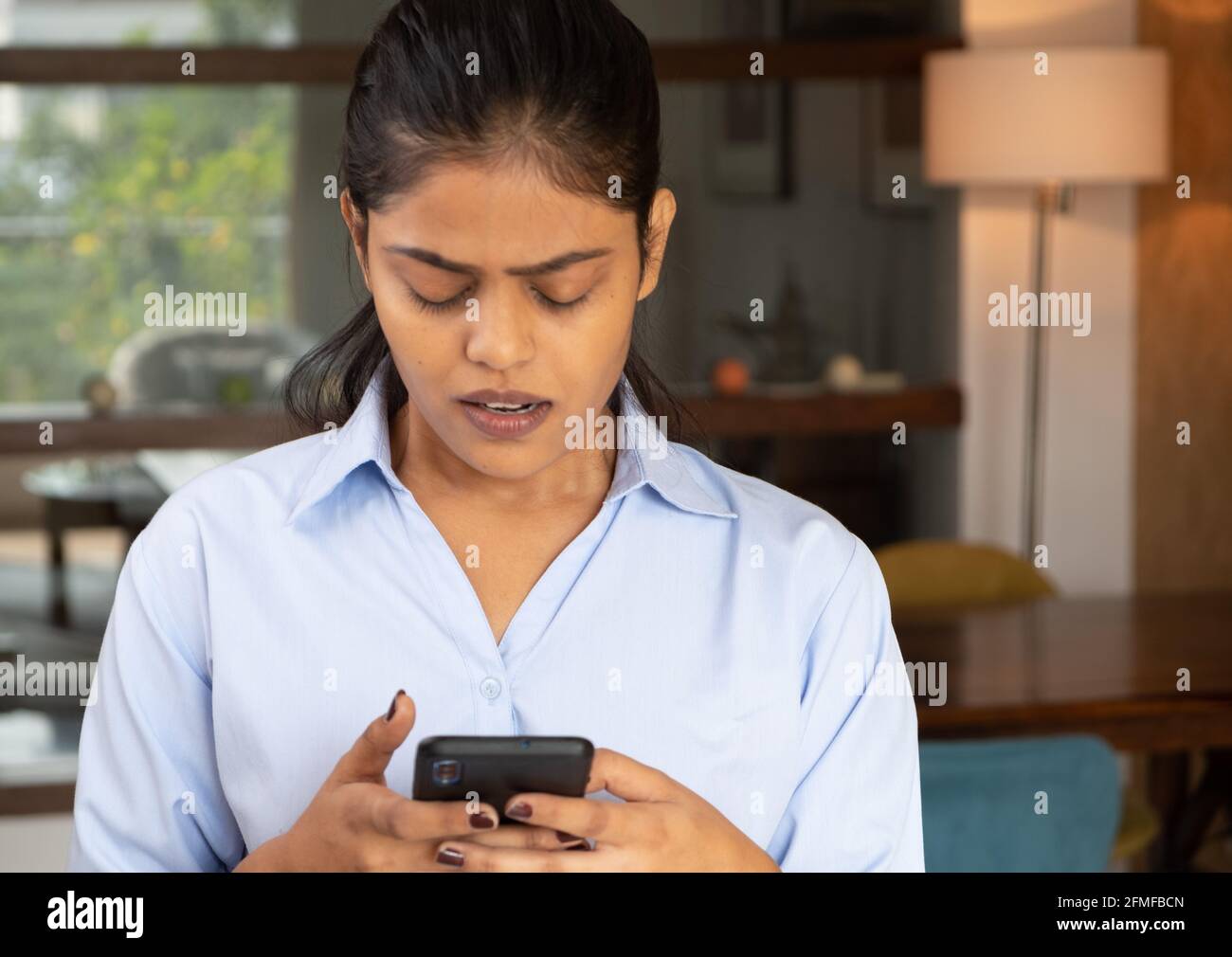 An Indian female texting on her phone Stock Photo - Alamy