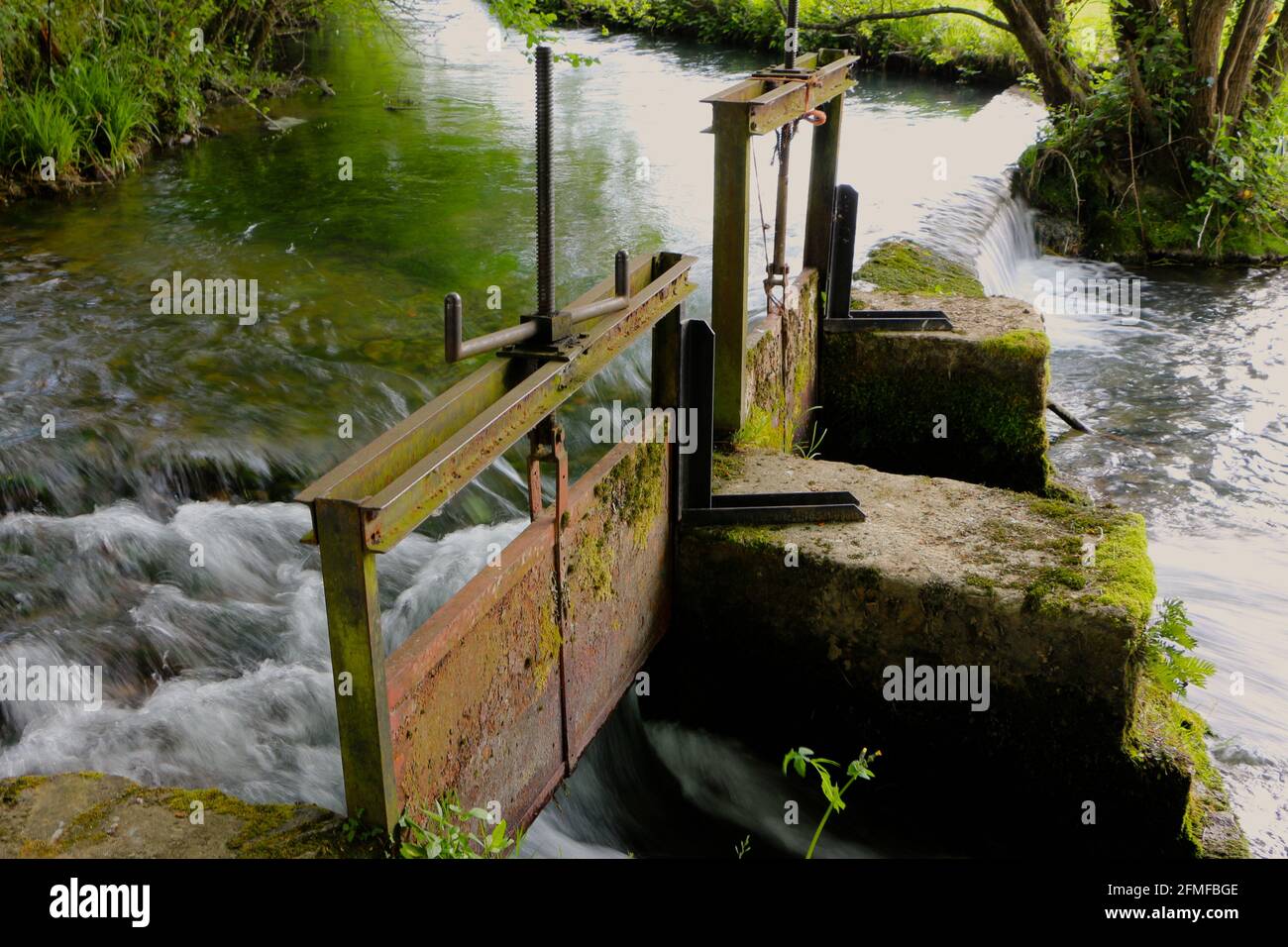 Two sluice gates raised allowing fast flowing river water on the River ...