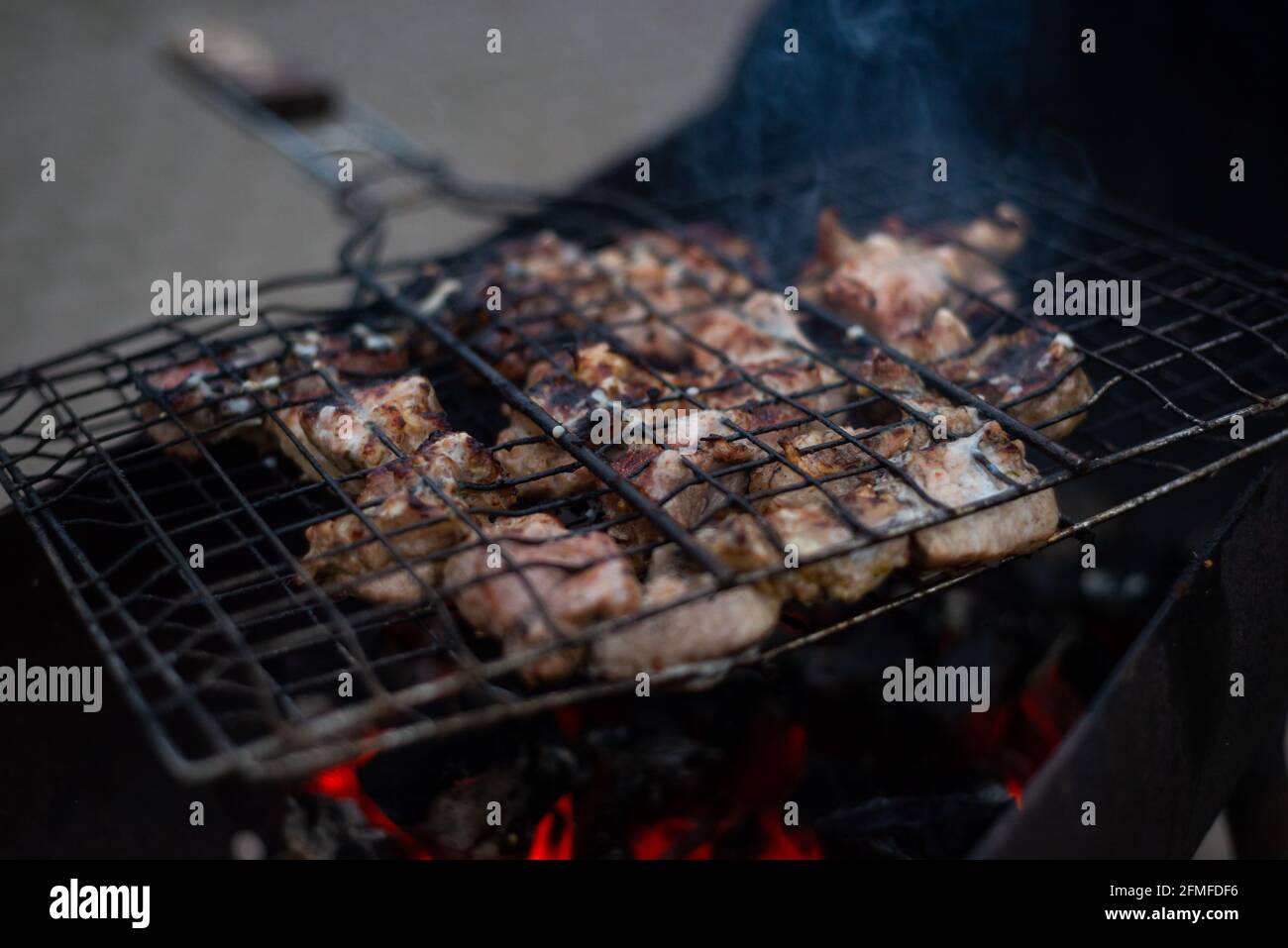 grilling meat on a metal grill with red coals Stock Photo - Alamy