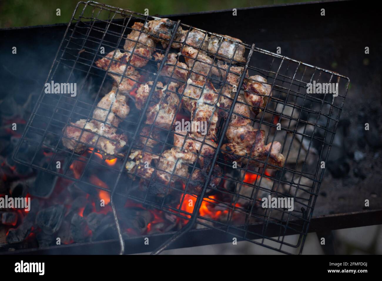grilling meat on a metal grill with red coals Stock Photo - Alamy