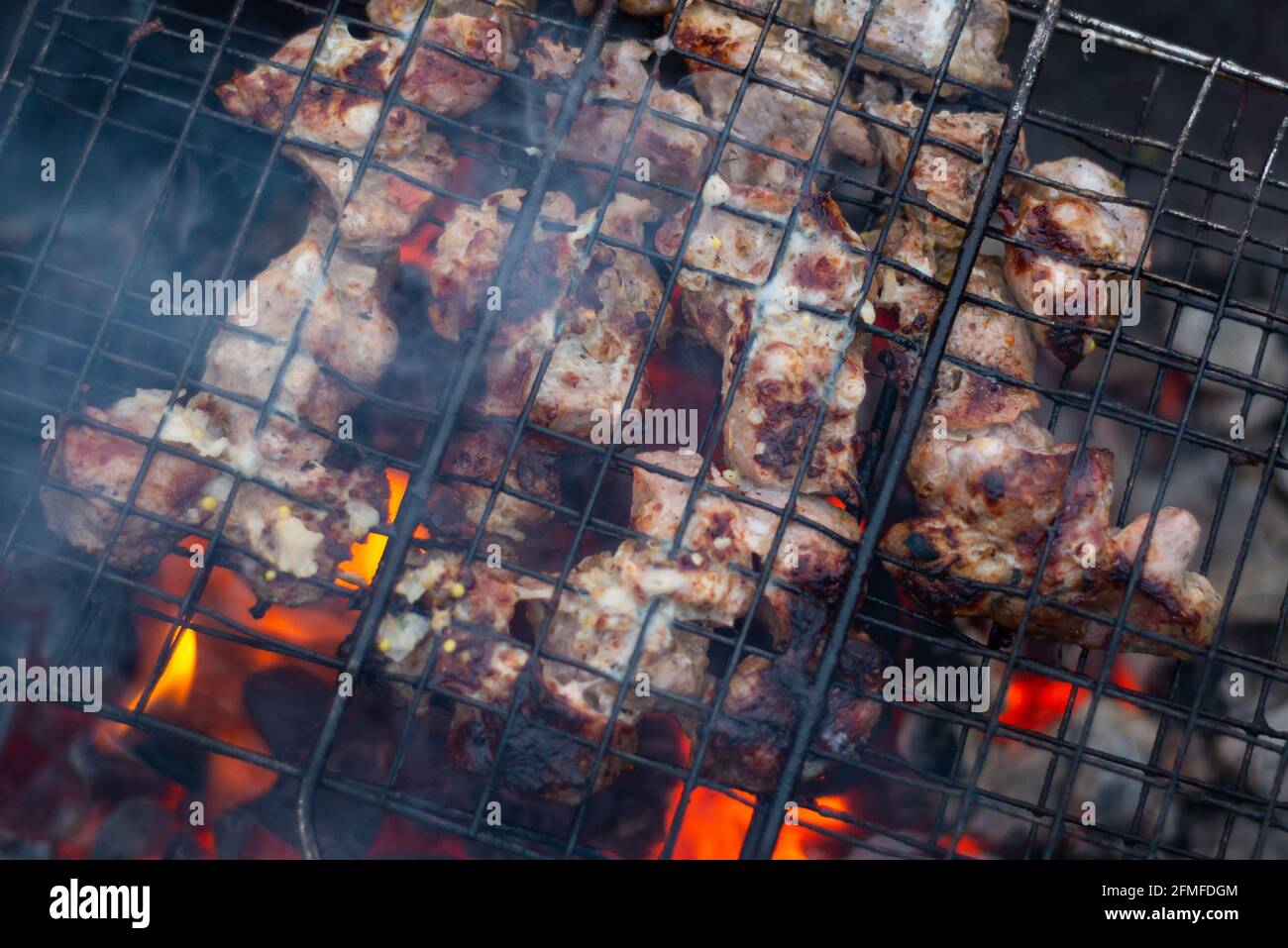grilling meat on a metal grill with red coals Stock Photo - Alamy