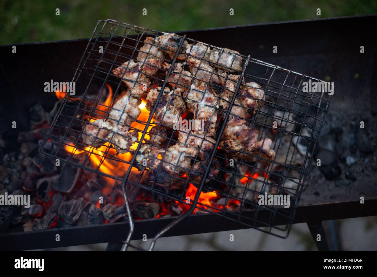 grilling meat on a metal grill with red coals Stock Photo - Alamy