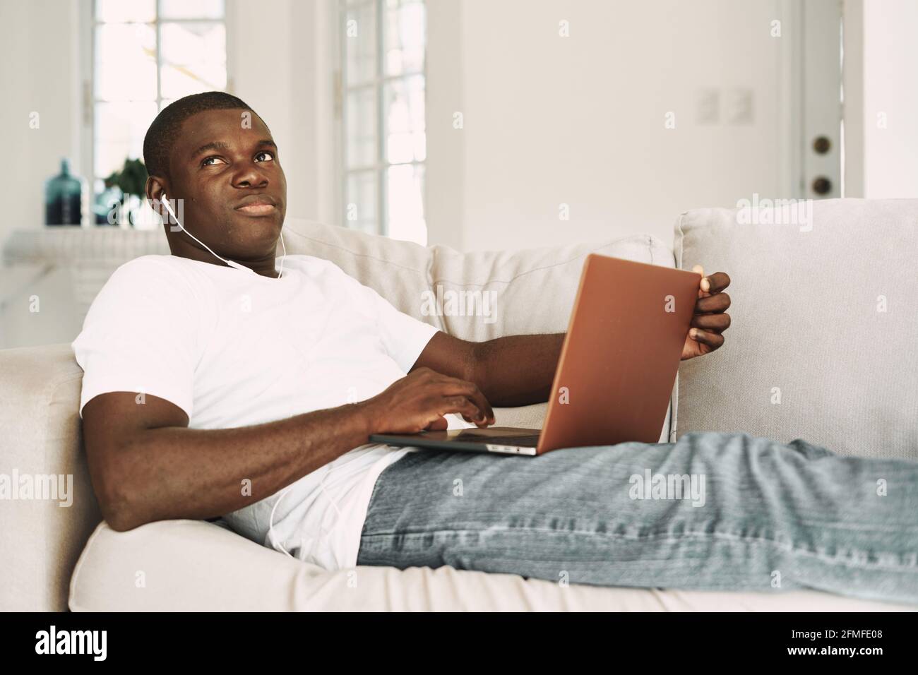 guy african with a laptop sitting on the couch freelancer education ...