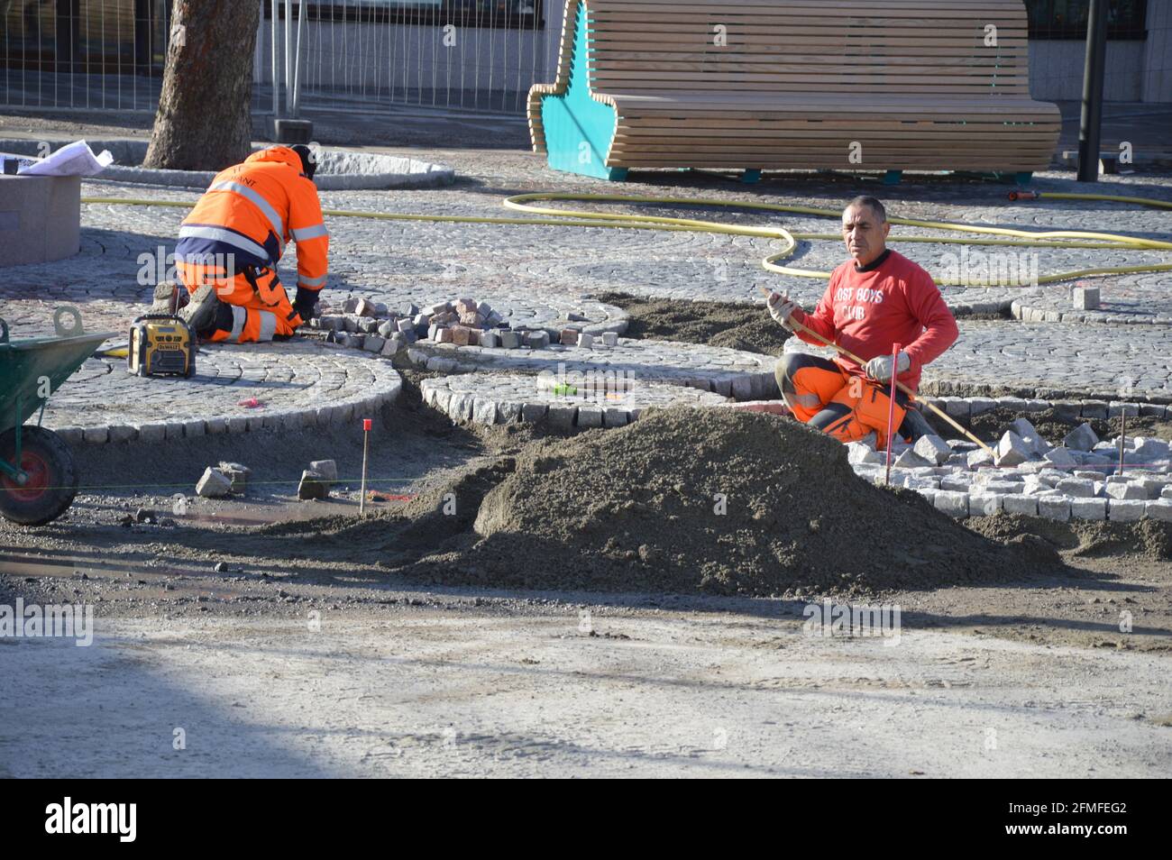 Mason workers making pavement construction works in central Kärrtorp ...