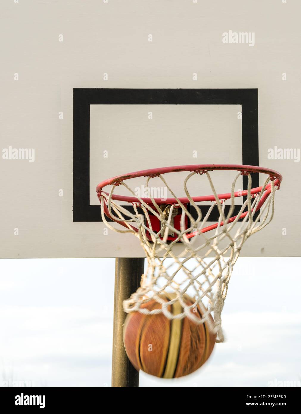 Basketball going through hoop Stock Photo - Alamy