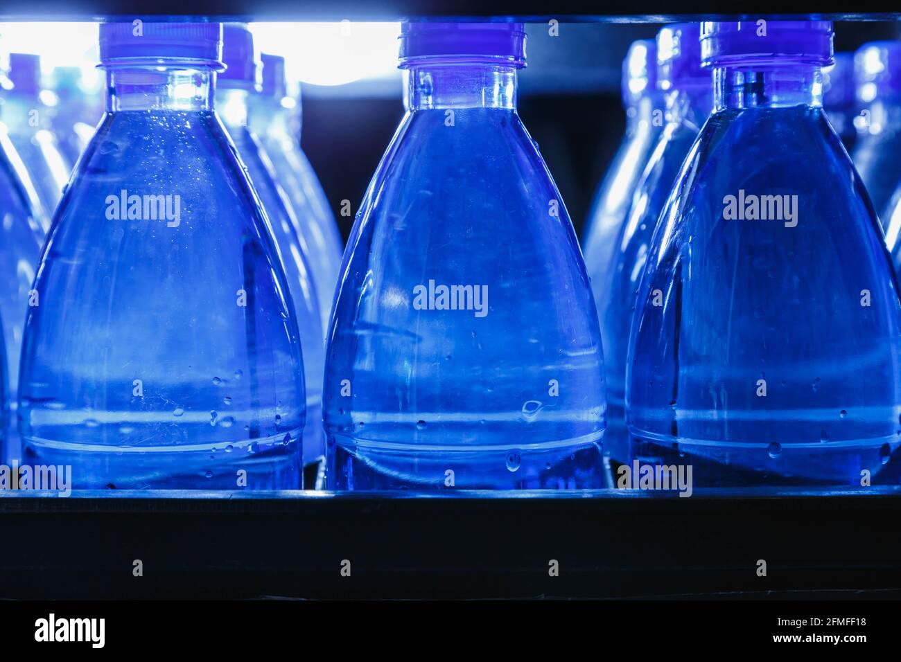 Bottles of drinking water in the water production plant Stock Photo - Alamy