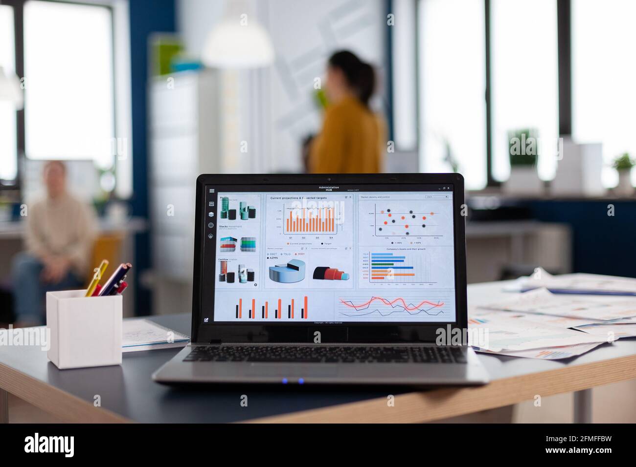 Close up of laptop in start up company office with charts and ...