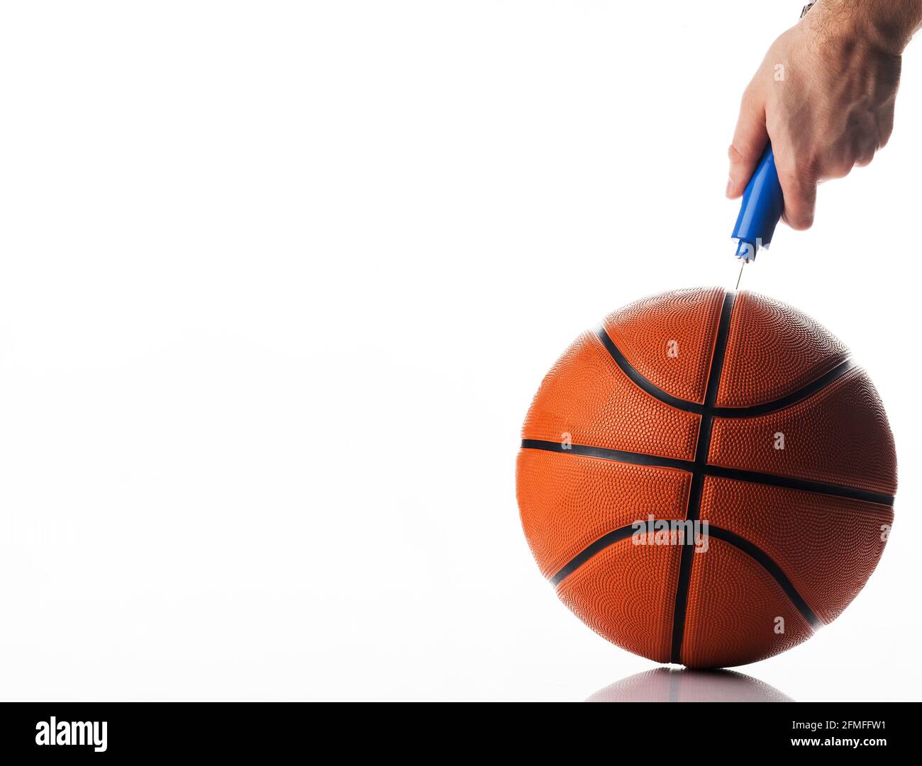 Basketball rubber orange ball inflated by pump on white background ...