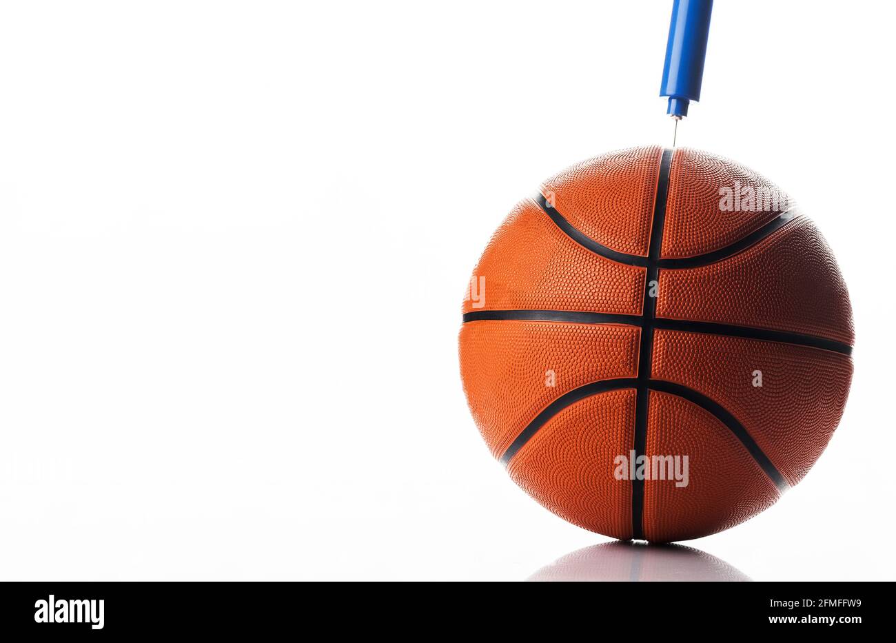 Basketball rubber orange ball inflated by pump on white background ...