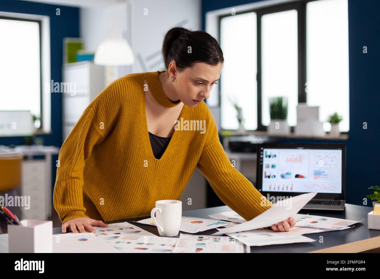 Corporate business woman reading statistics on documents paperwork ...