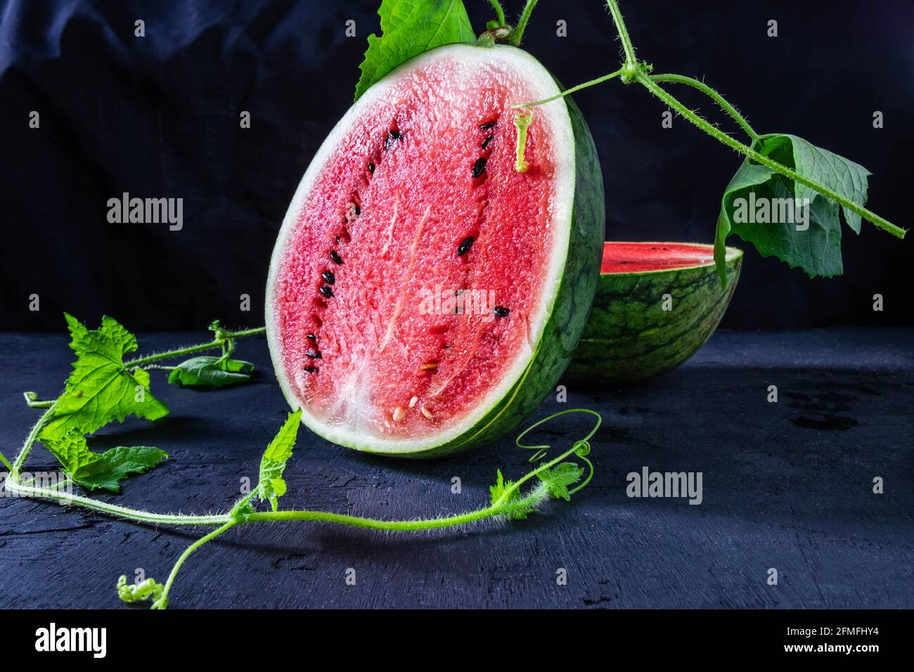 Fresh Water melon fruit cut in half on a black background Stock Photo ...