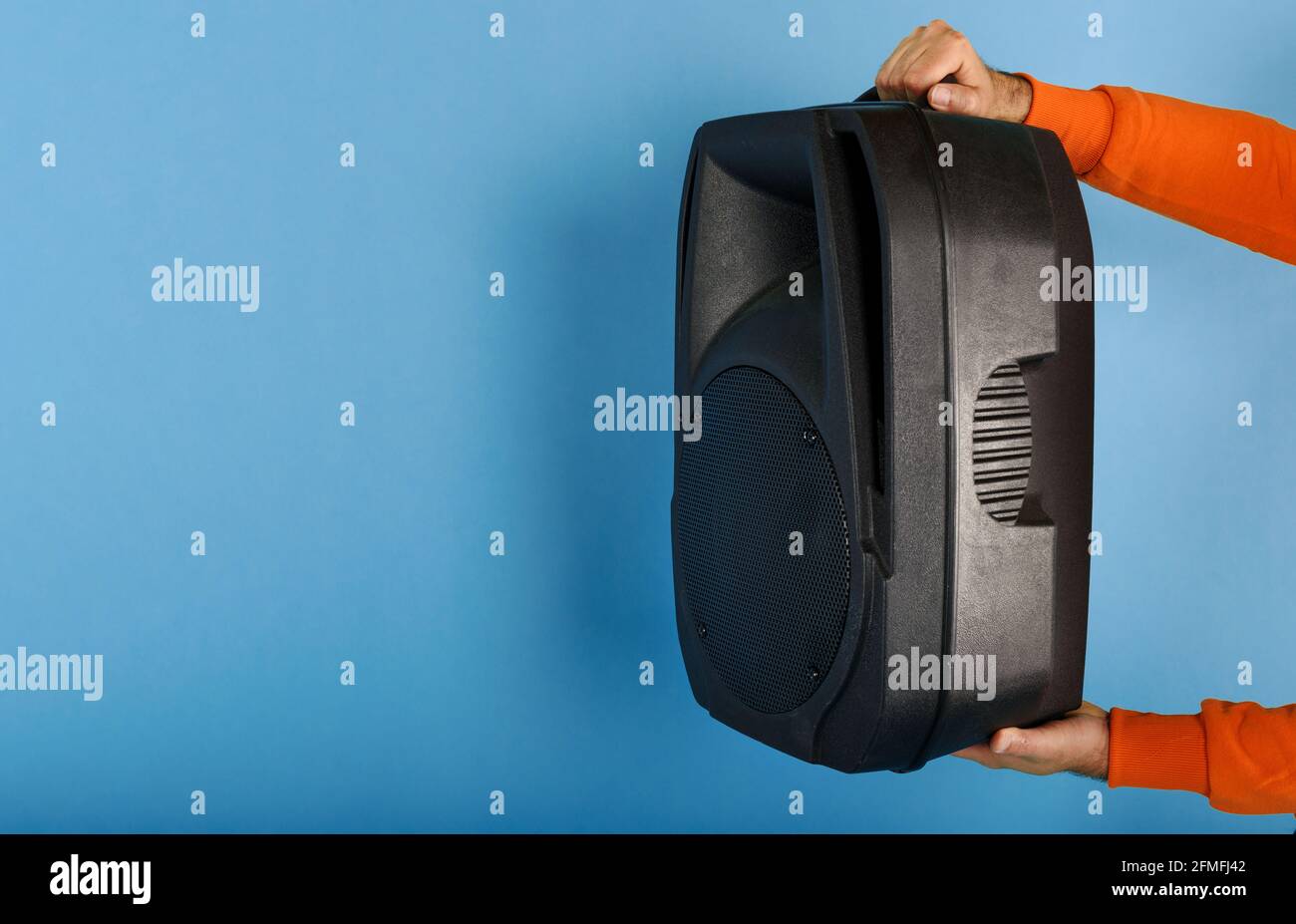 Man holds a big sound box to listen music. blue background Stock Photo ...