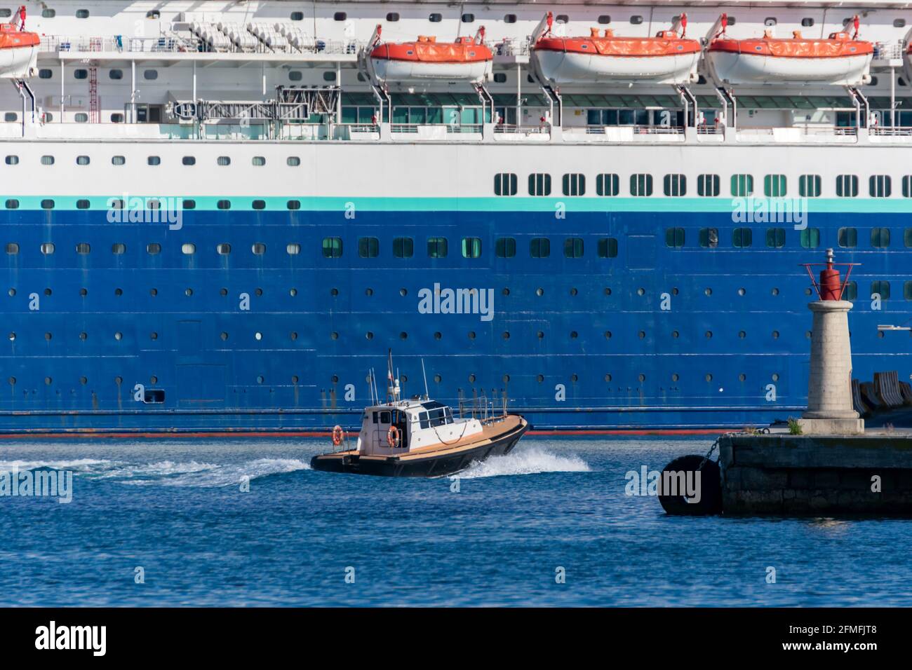Small boat leaving the port at the same time as a large ferry enters ...