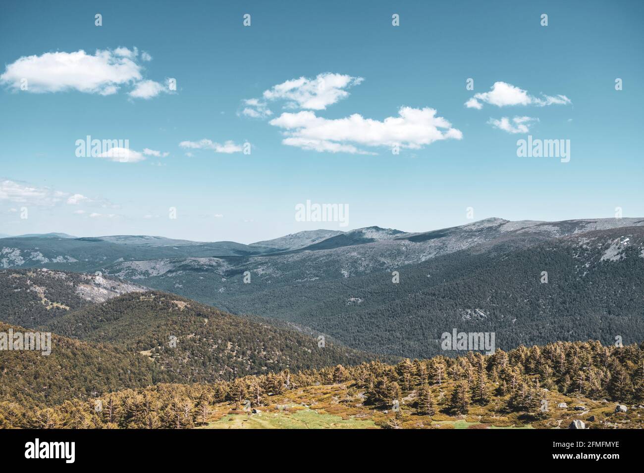 Horizontal landscape of a mountain with large clouds casting their ...