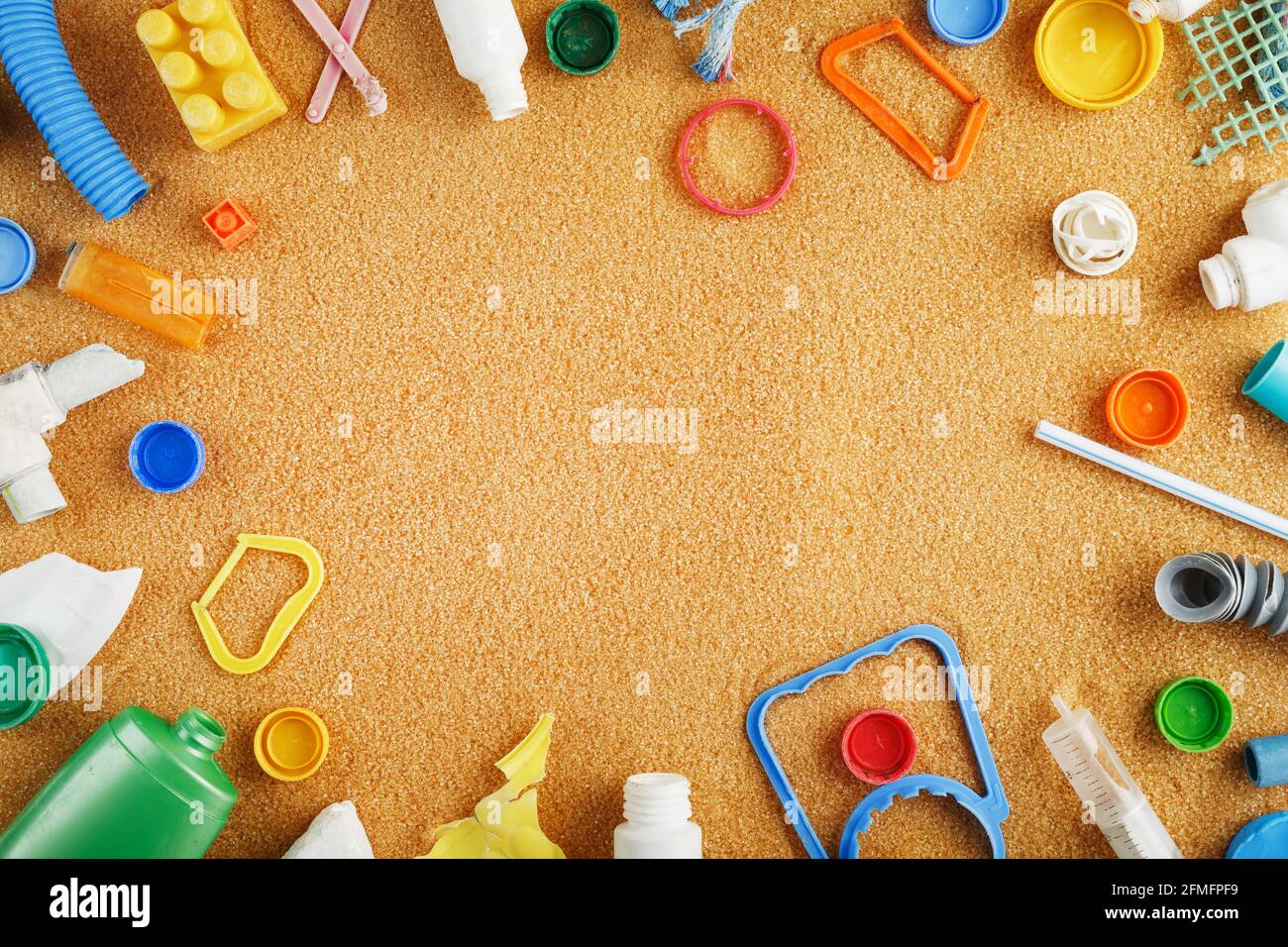 Garbage made of colorful plastic on an oceanic sandy beach. Global ...