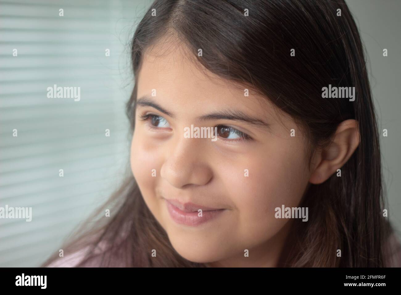 A closeup of a happy little Colombian Hispanic girl Portrait of hope ...