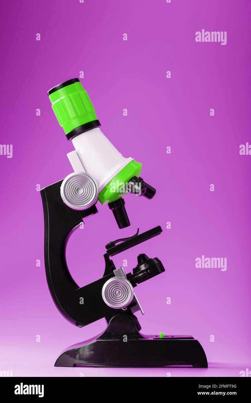 Laboratory microscope on a pink background for scientific research on a ...