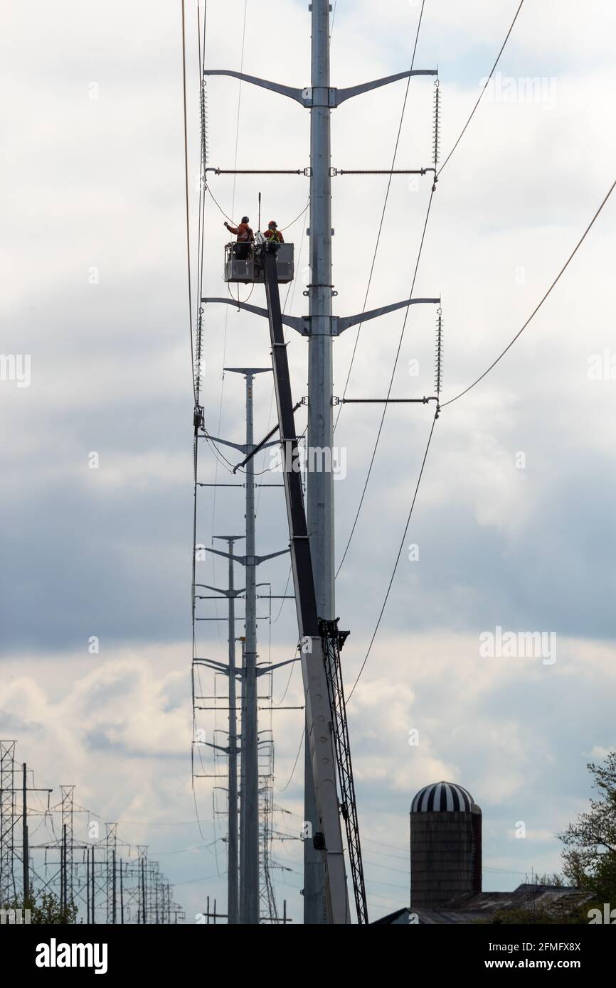 Electricity utility workers maintain power distribution lines in ...