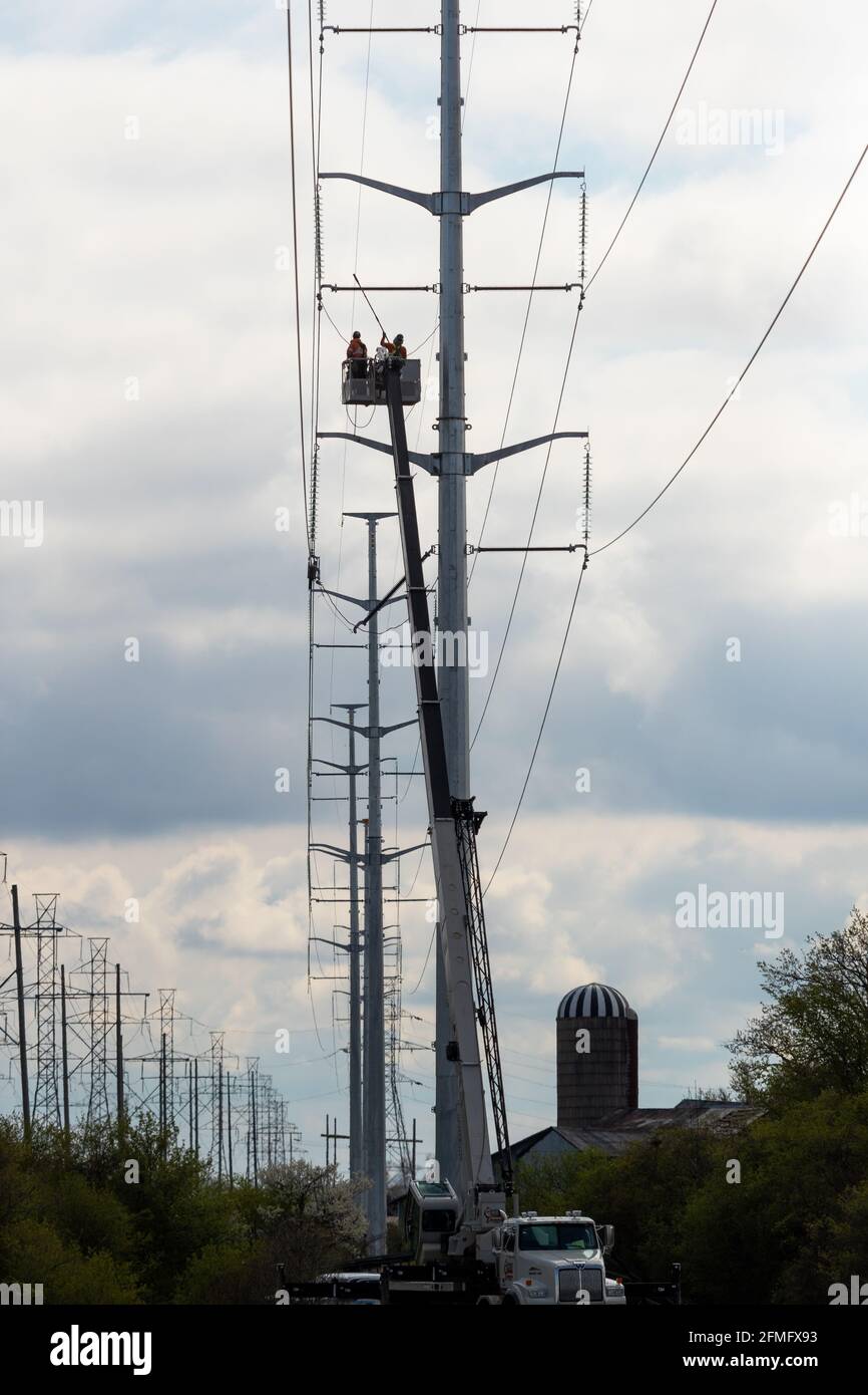 Electricity utility workers maintain power distribution lines in ...