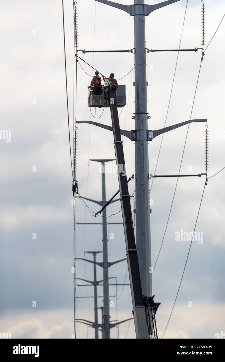 Electricity utility workers maintain power distribution lines in ...
