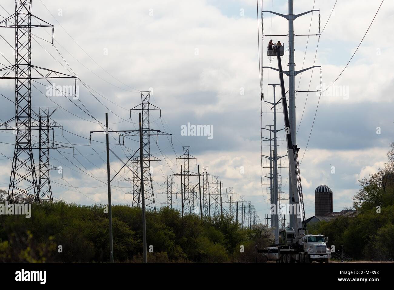 Electricity utility workers maintain power distribution lines in ...