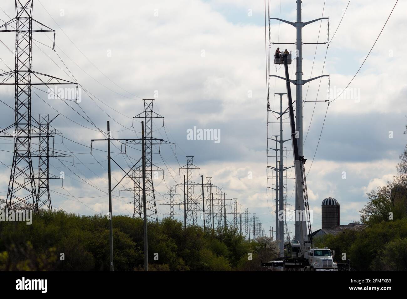 Electricity utility workers maintain power distribution lines in ...