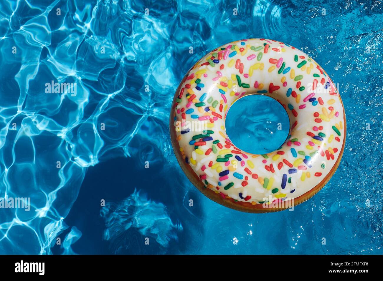 Inflatable donut ring in blue swimming pool Stock Photo - Alamy