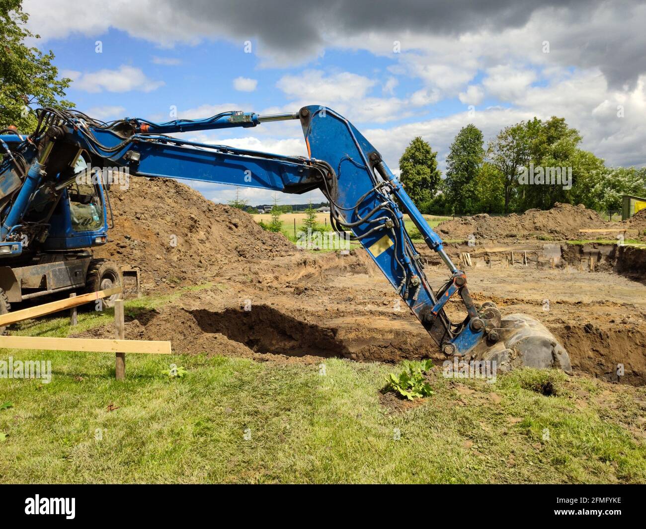 A work excavator digging a trench for the foundation of a building ...