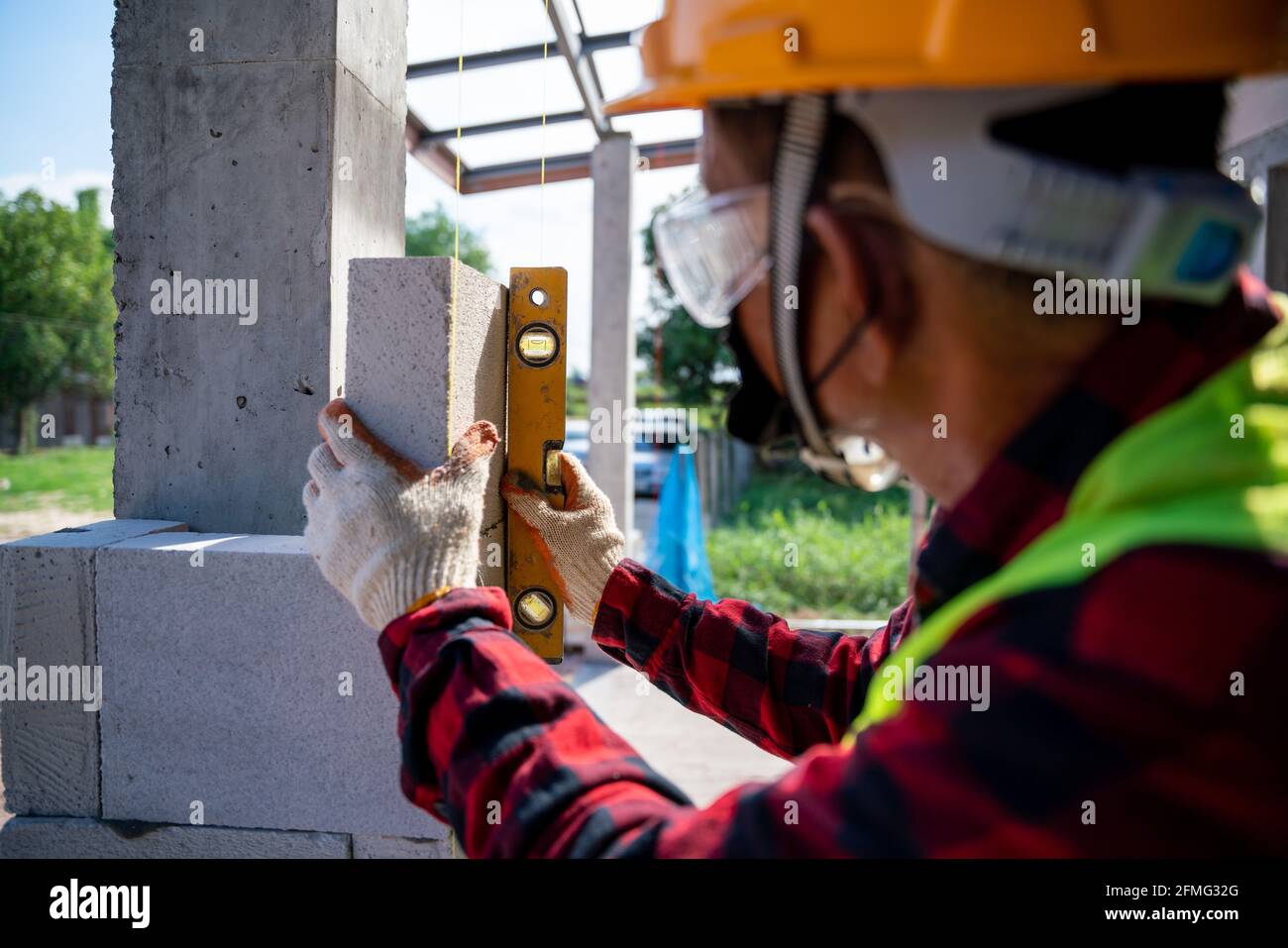Close-up bricklayer builder using the water level, check the ...