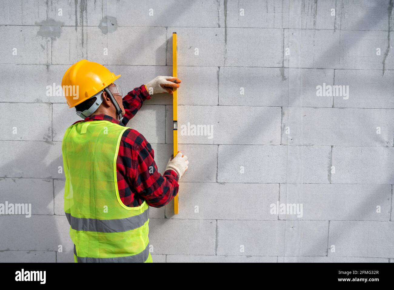 bricklayer builder using the water level, check the inclination of ...