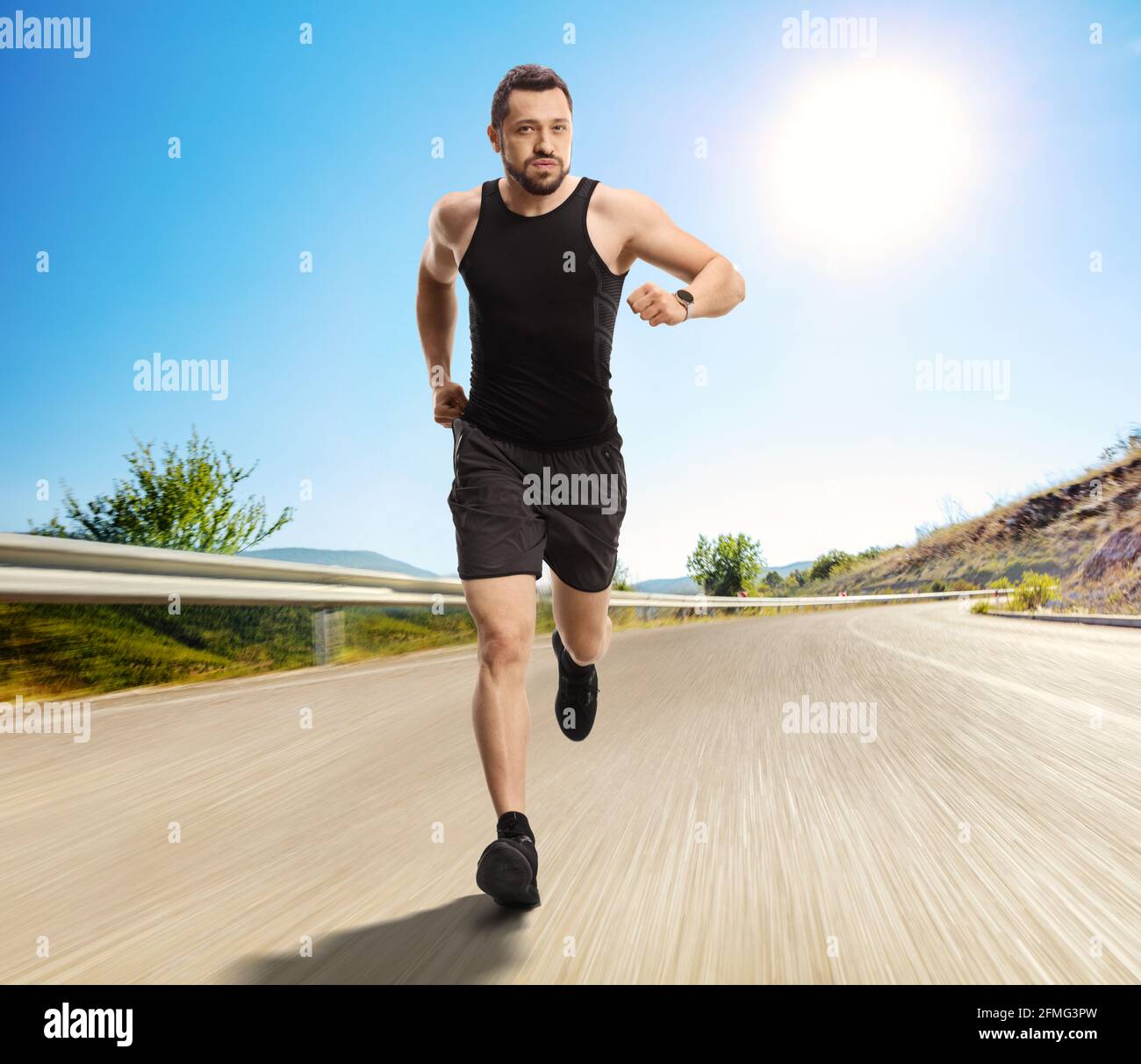 Full length portrait of a young man with a smartwatch running on an ...