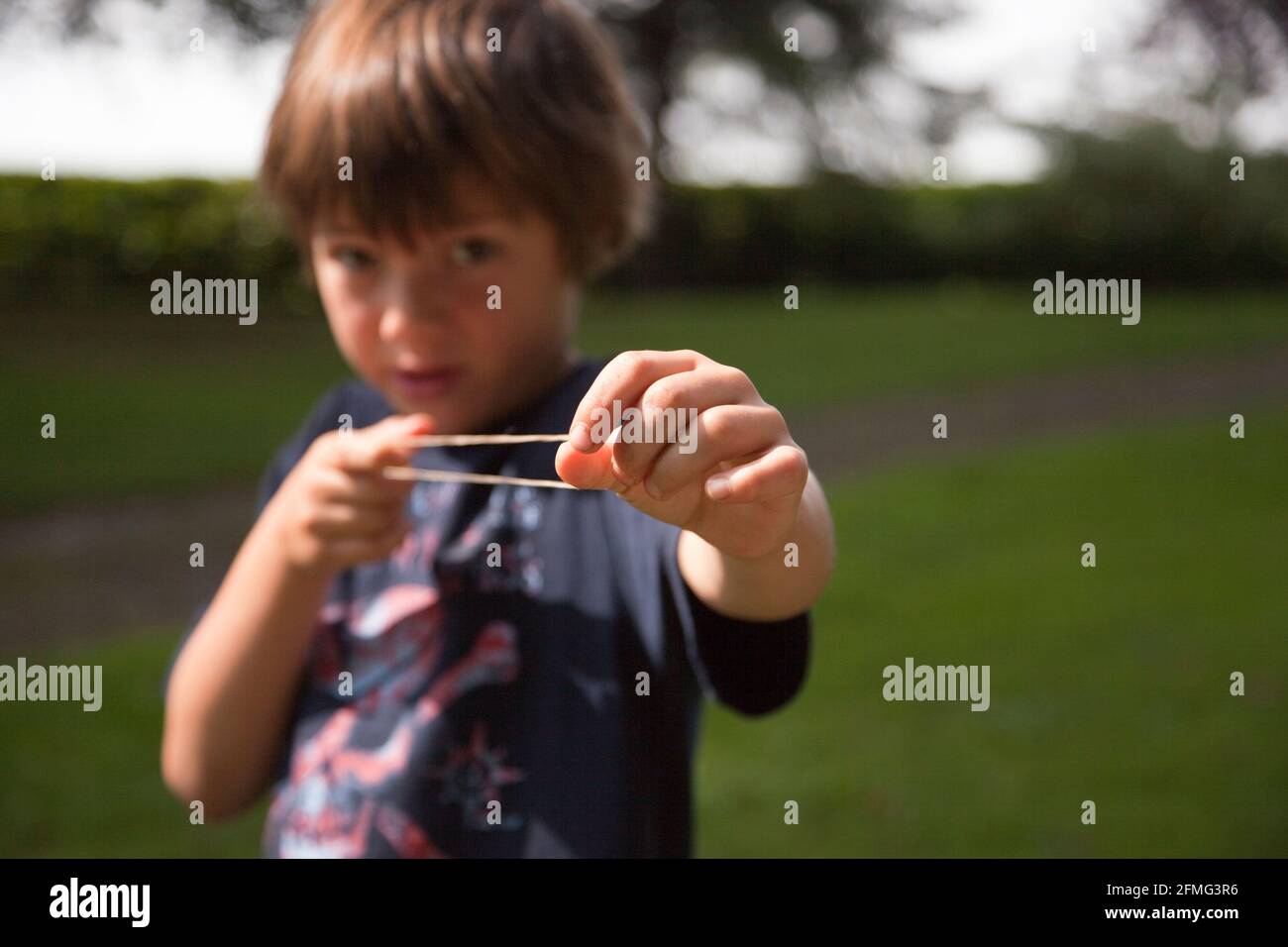 child firing rubber band,play,game Stock Photo - Alamy