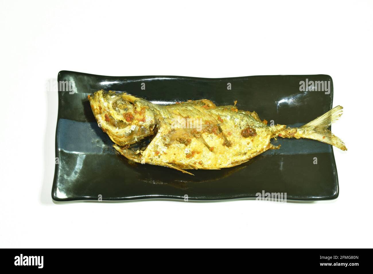 deep fried mackerel fish with turmeric on plate in white background ...