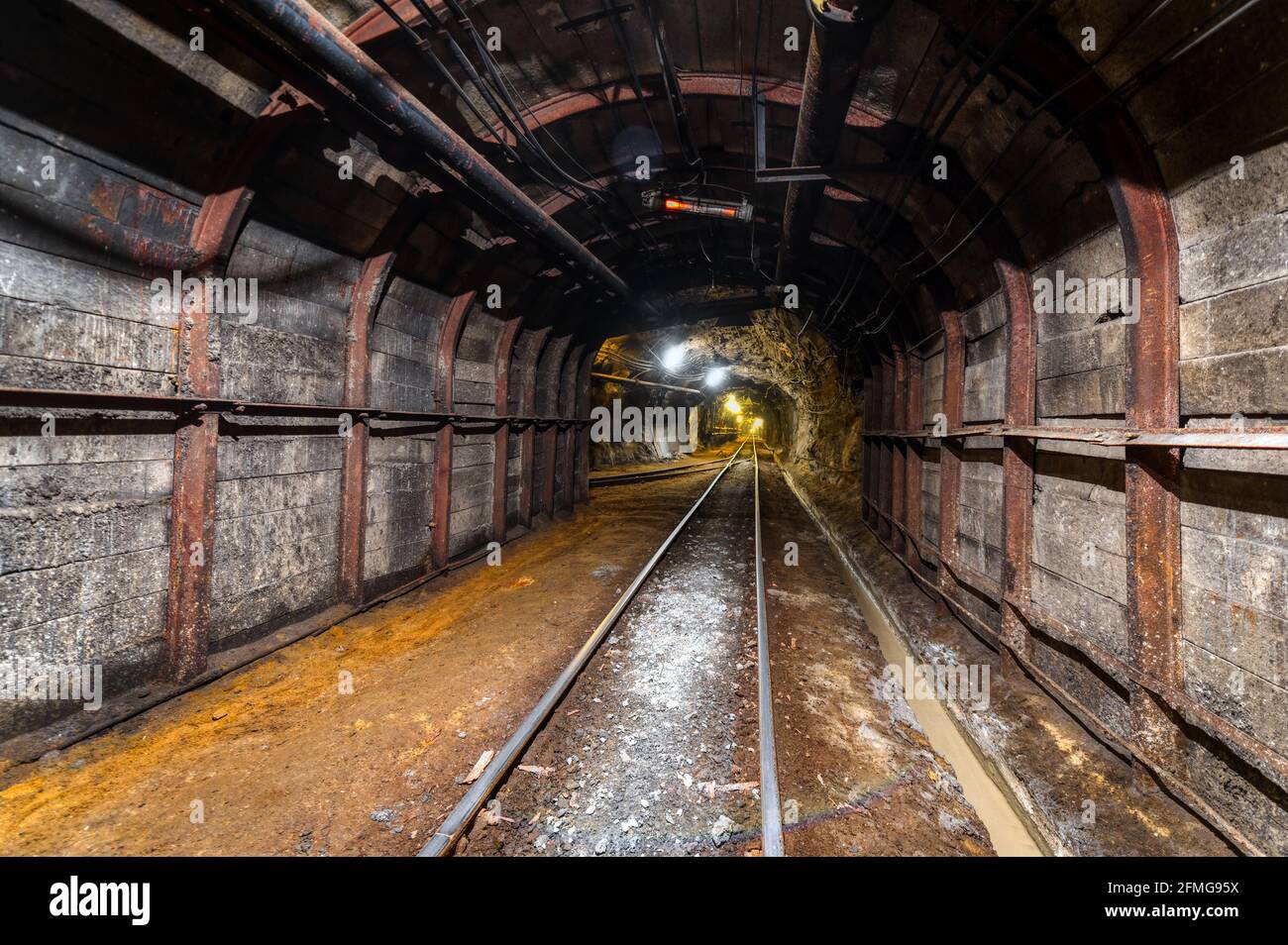 Tunnel of the mining of an underground mine. Lots of pipelines on the ...
