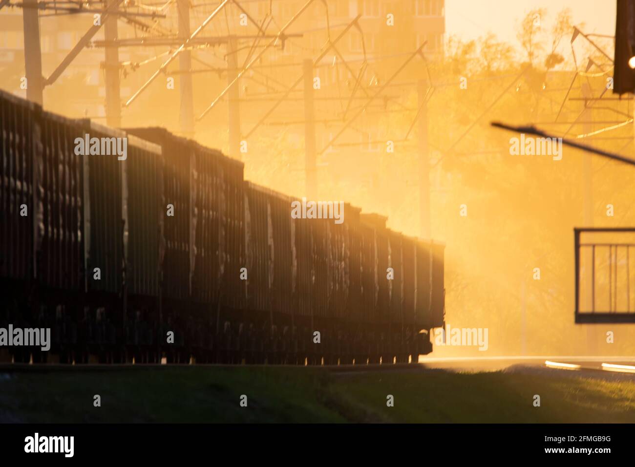 Train cars on railway tracks. Sunlight that penetrates the fog and ...