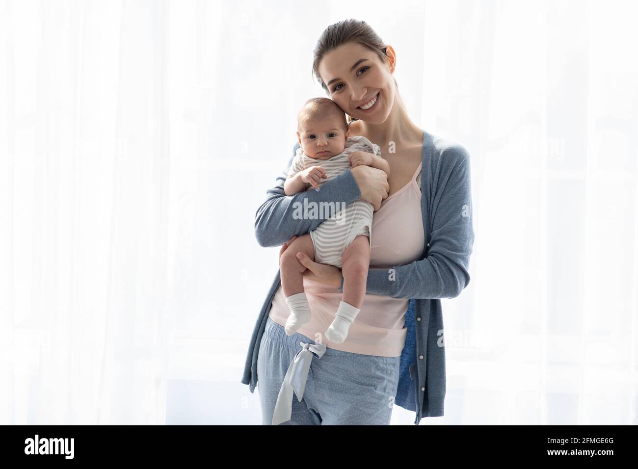 Happiness Of Motherhood. Beautiful Young Woman Holding Newborn Baby In Her Arms Stock Photo - Alamy