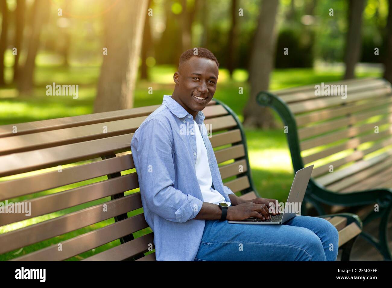 Happy black guy with laptop computer working or studying online on ...