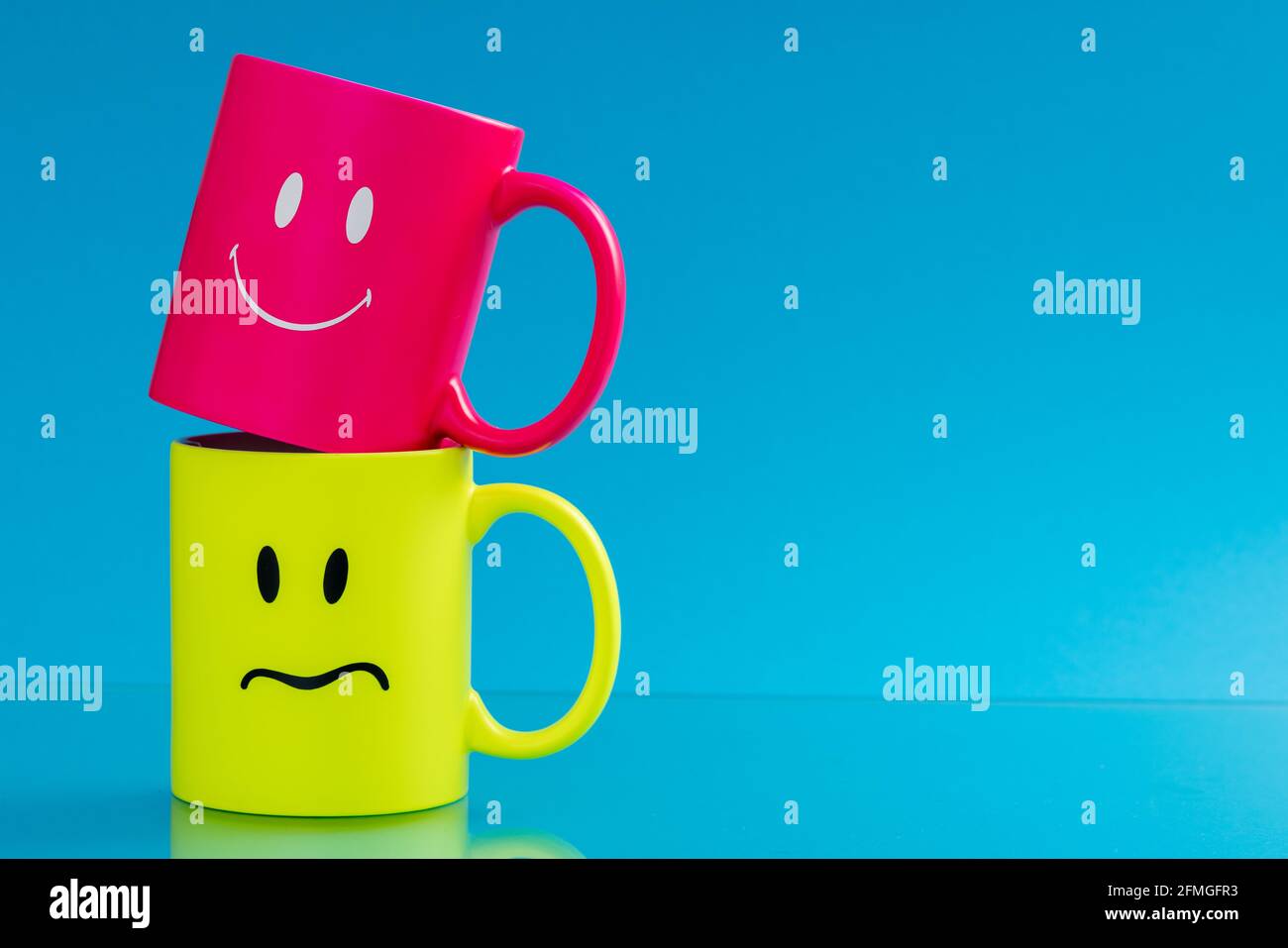Two mugs with happy and sad emotions on the background. Concept, Coffee ...