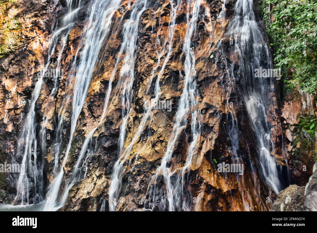 Strong streams of the waterfall seem to wrap around and lick the rock ...