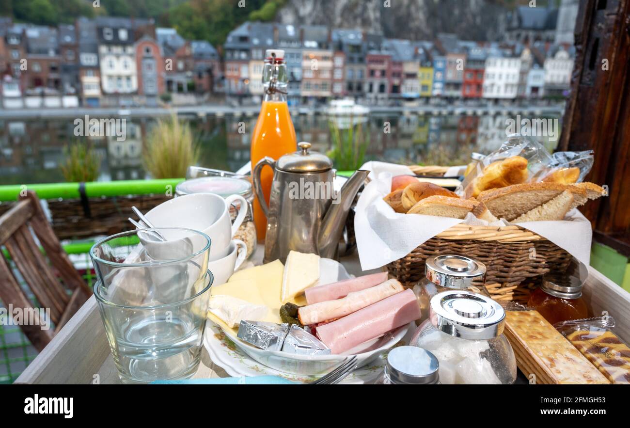 Breakfast served in big tray in hotel room with view on Maas river in ...