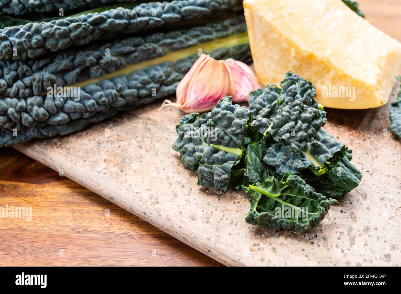Vegetarian cooking with black flat leaves of cavolo nero tuscan cabbage ...