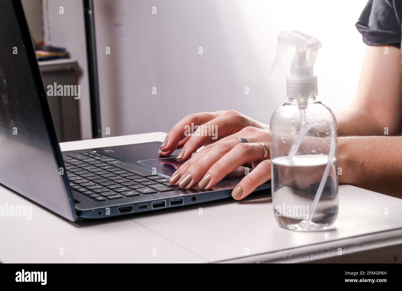 A closeup shot of female hands typing on a laptop keyboard on a desk ...