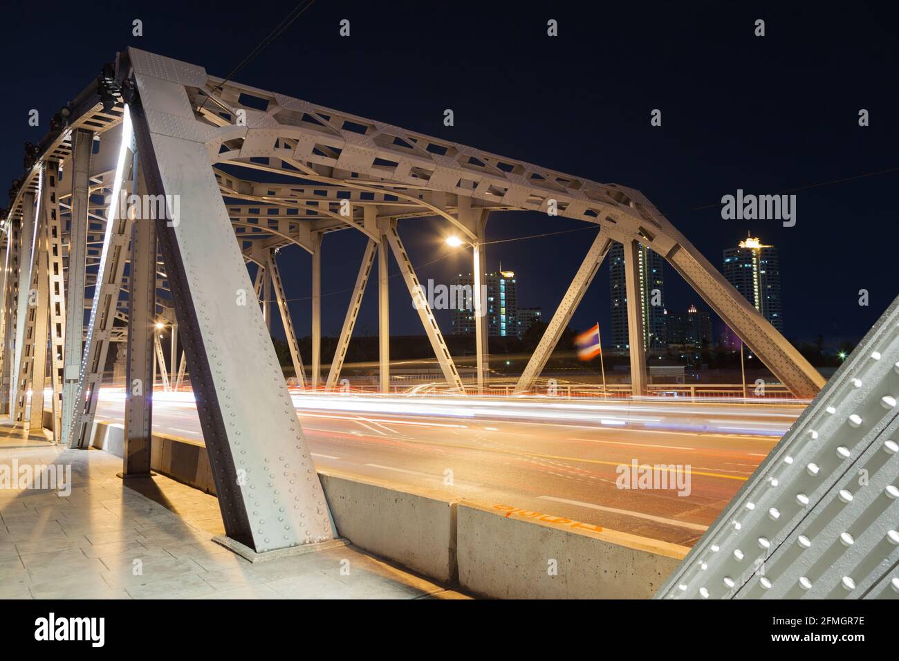 Traffic at night. The light from cars traveling across the bridge at ...